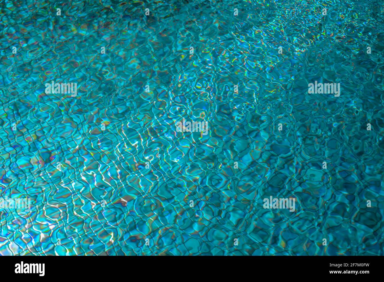 The texture of pure azure water in the swimming pool surface with ...
