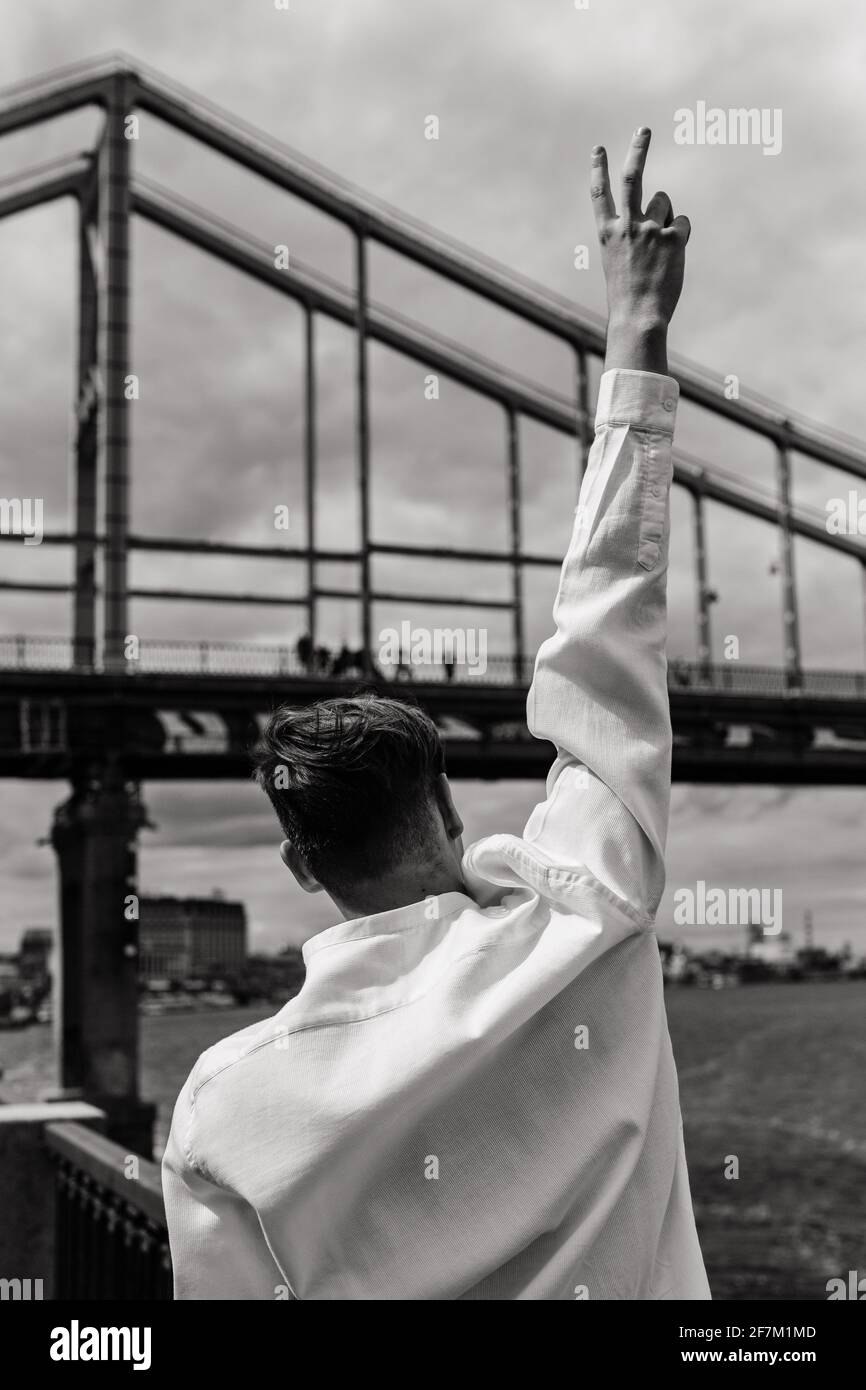 The guy with the raised hand shows the pis gesture on the background of ...