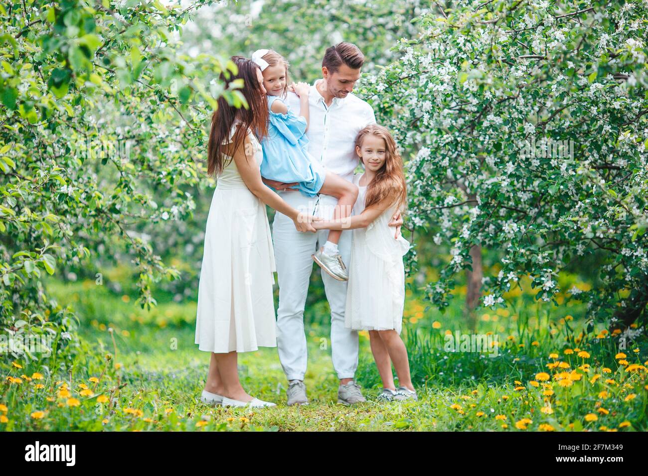Adorable family in blooming cherry garden on beautiful spring day Stock ...