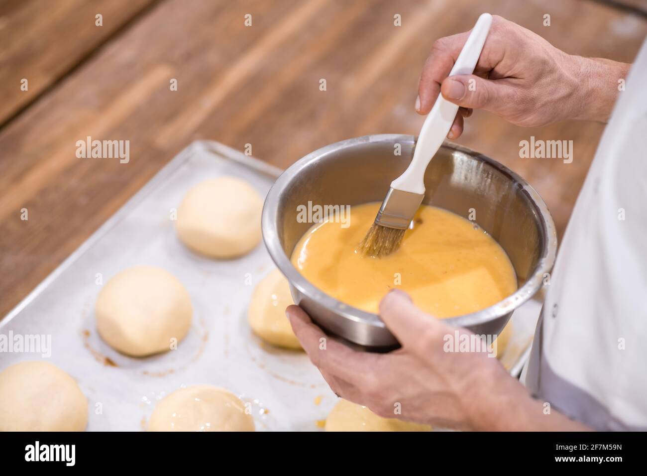 Male hands holding bowl of icing over sheet Stock Photo - Alamy