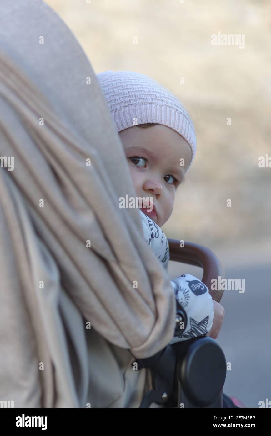 Cute baby girl in baby stroller outdoor, looking at camera Stock Photo ...
