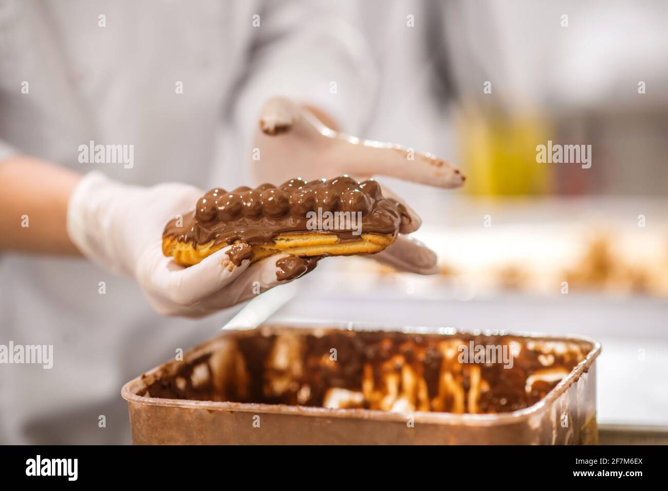 Hand holding chocolate eclair hi-res stock photography and images - Alamy