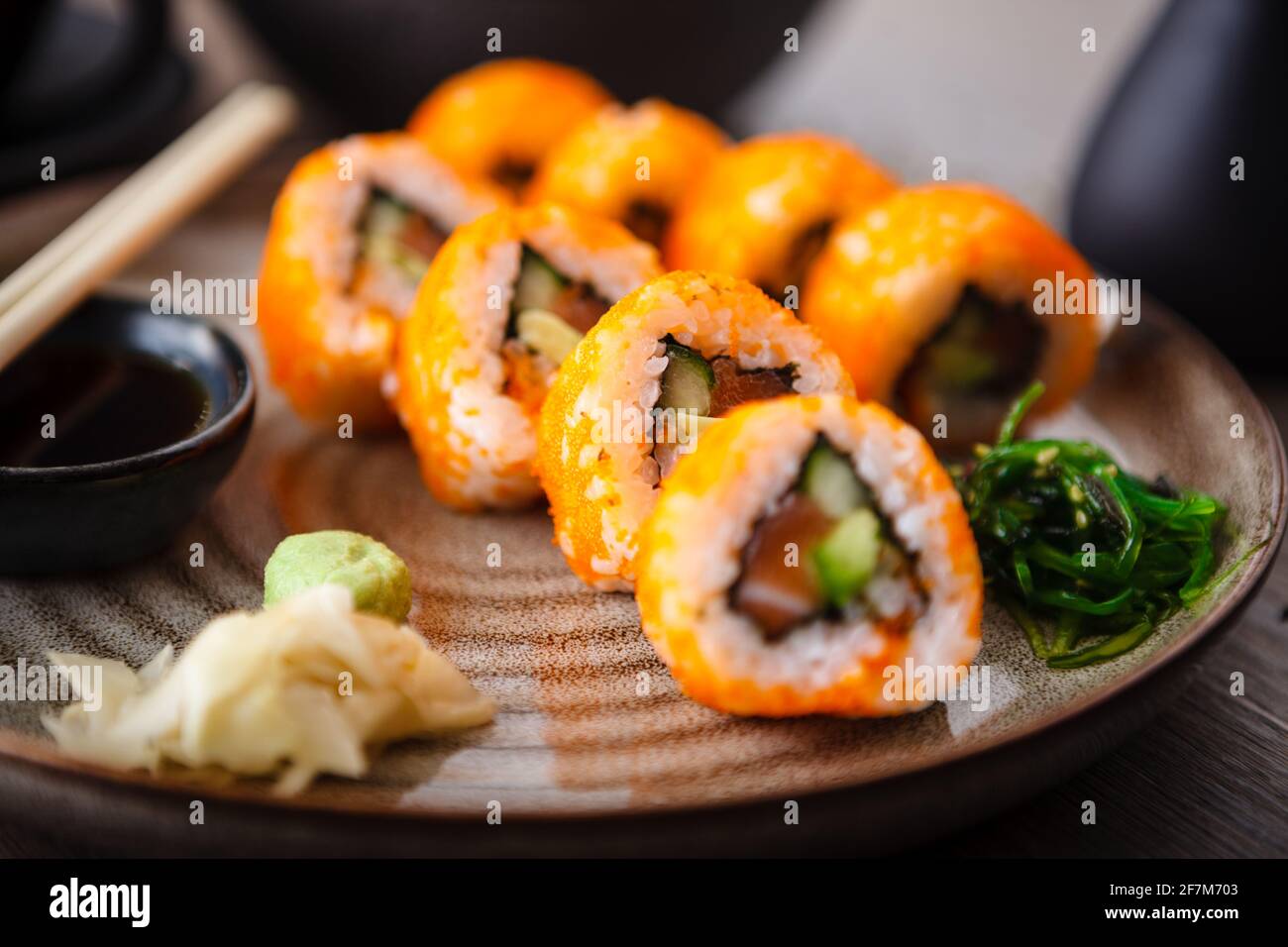 Sushi maki rolls with salmon, avocado, cucumber, flying fish roe on a ...