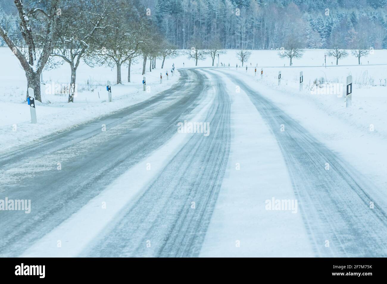 Lonely slippery icy winter road traffic with white snowy track. The ...