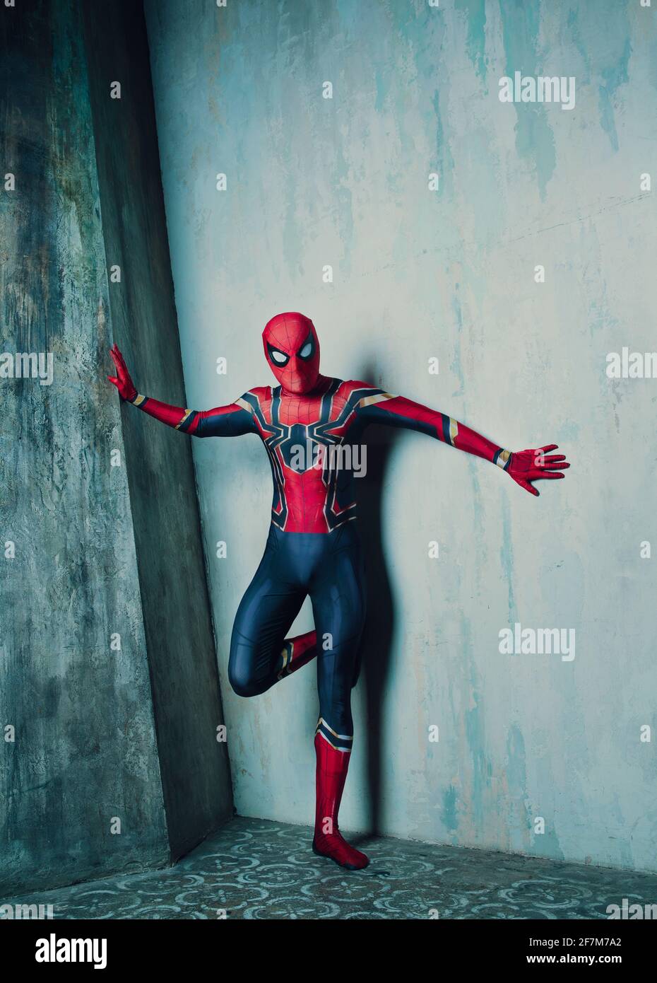 actor dresssed as Spiderman posing against an old wall in the studio ...