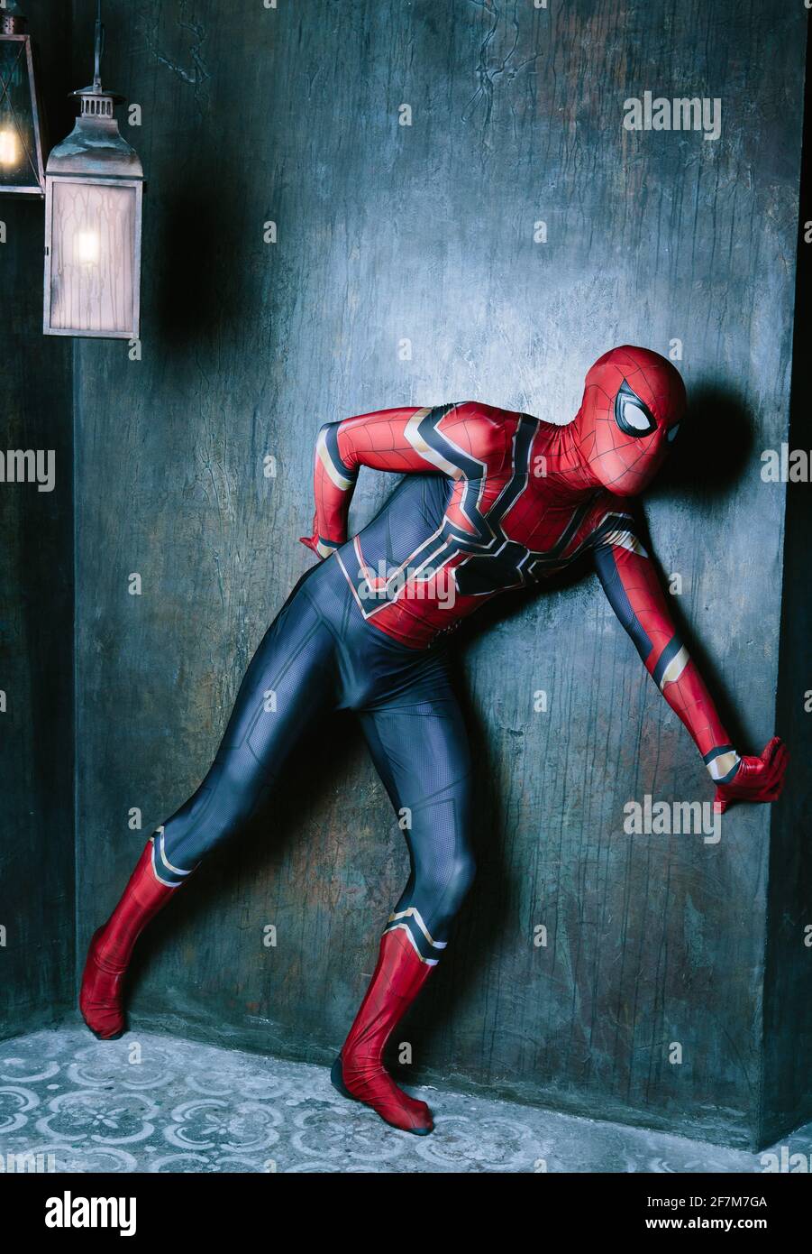 actor dresssed as Spiderman posing against an old wall in the studio ...