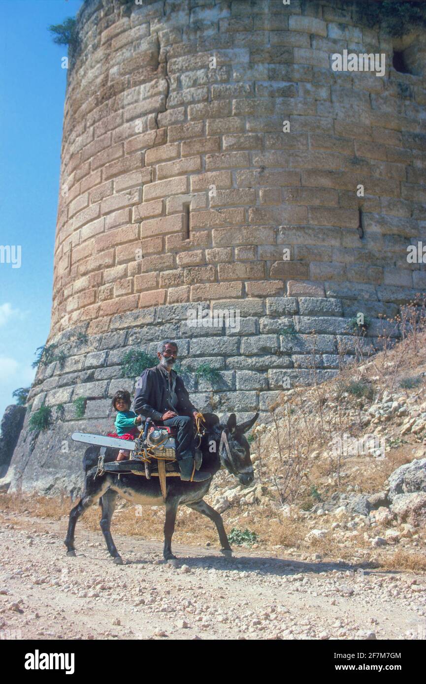 Father and daughter riding donkey past Koz Castle Turkey Stock Photo ...