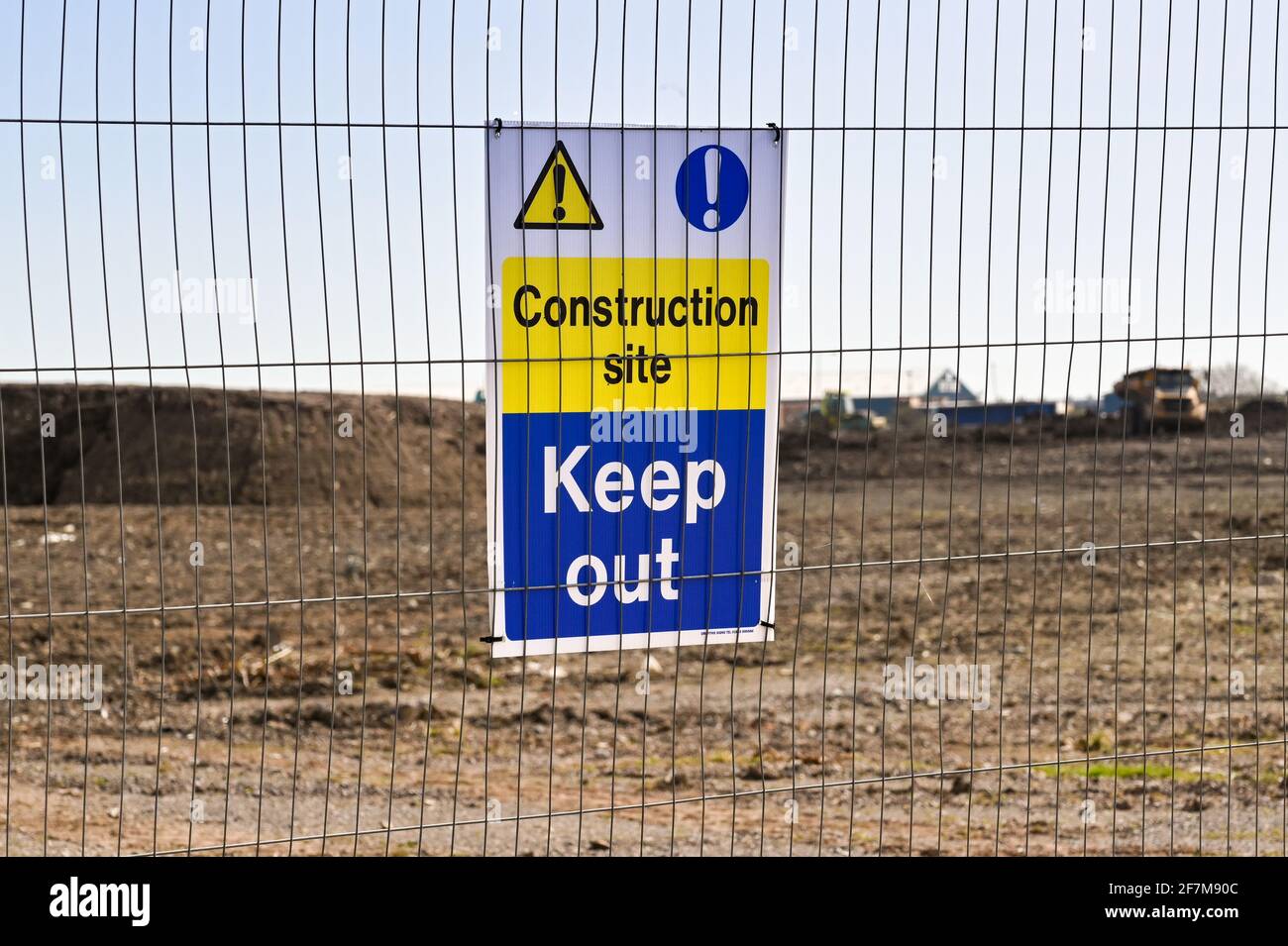 Keep out sign on a wire mesh fence around a construction site. No ...