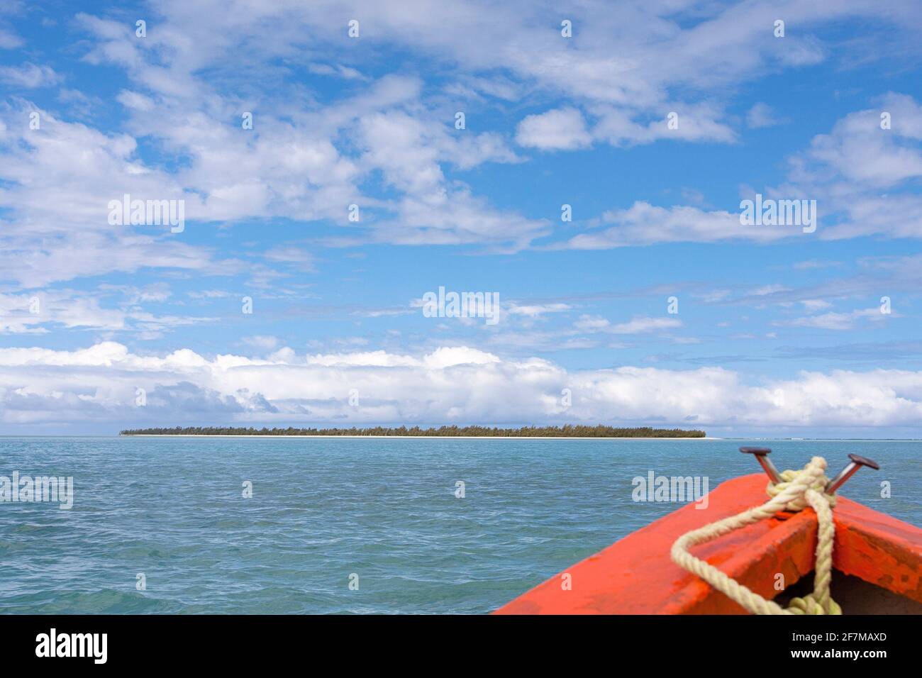 Traditional wooden fishing boat sailing towards small uninhabited ...