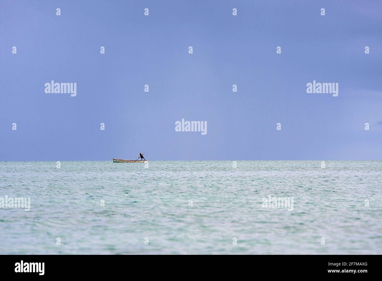 Local fisherman fishing from a traditional wooden fishing boat in a ...