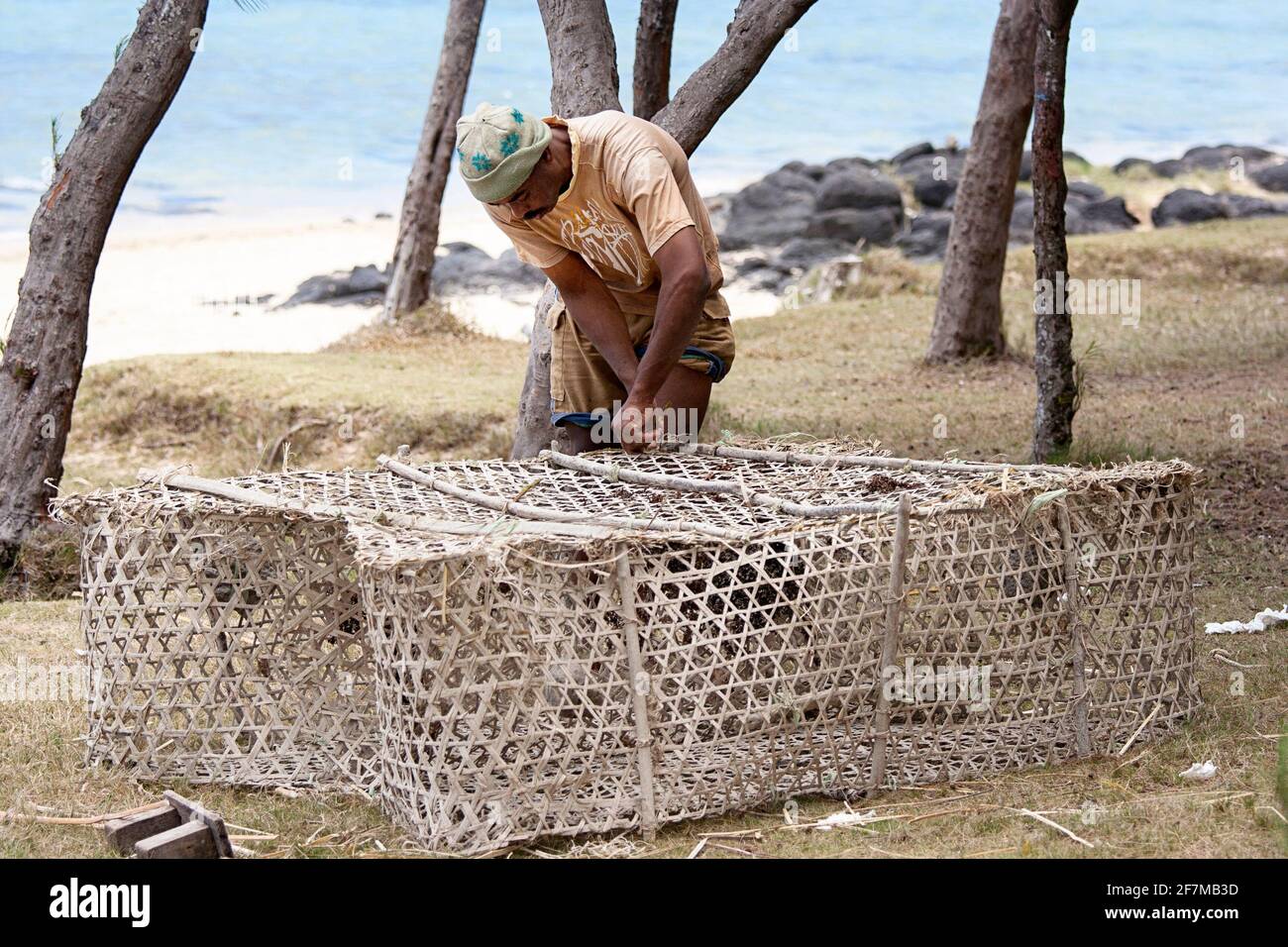 Local fisherman repairing his bamboo fish trap on the beautiful island ...