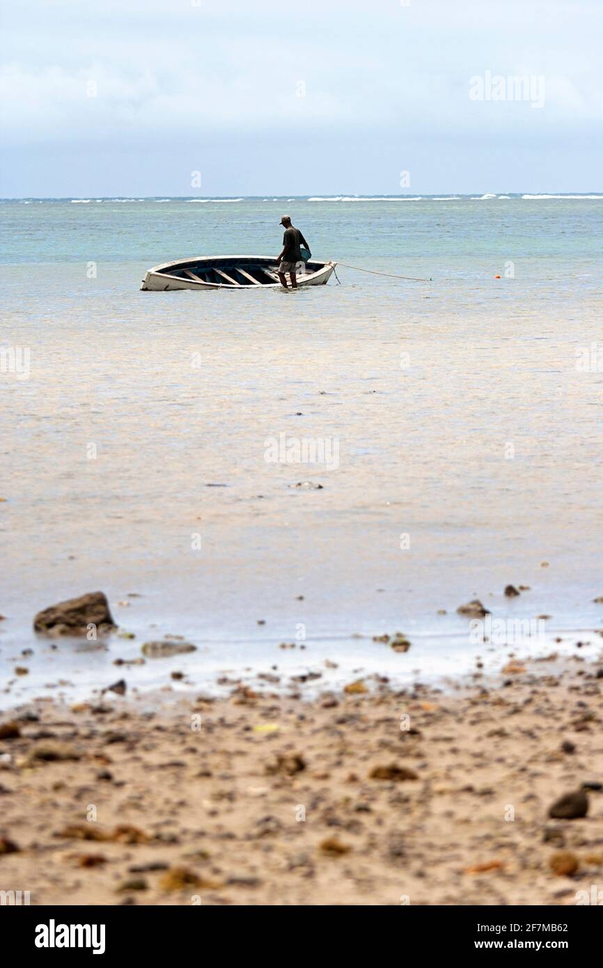Fisherman and his traditional sailing boat turned to the side in the ...