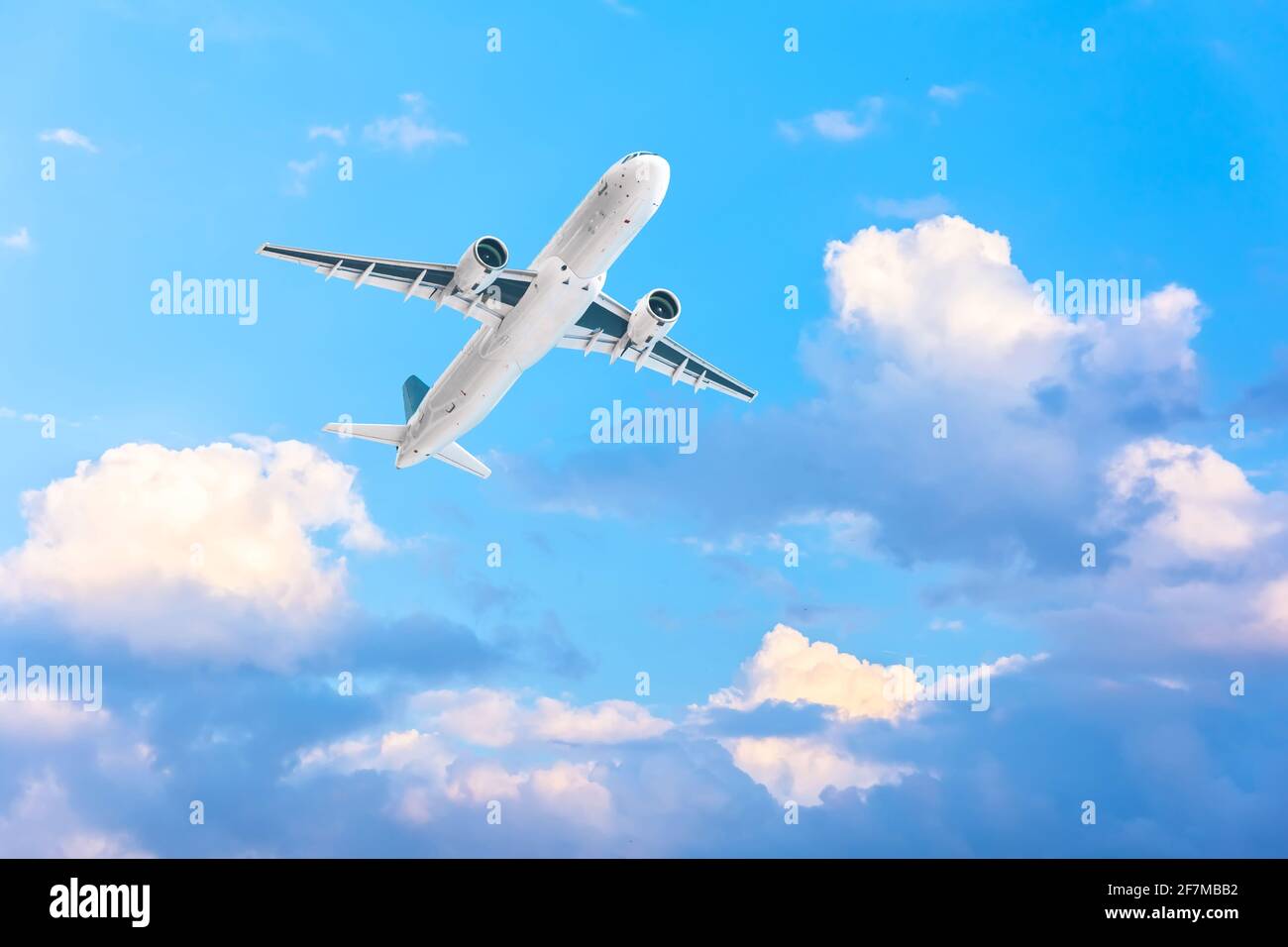 Airplane gaining height among the evening clouds Stock Photo - Alamy