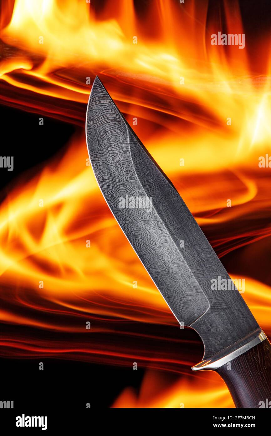 Damascus steel knife on the fire background Stock Photo - Alamy