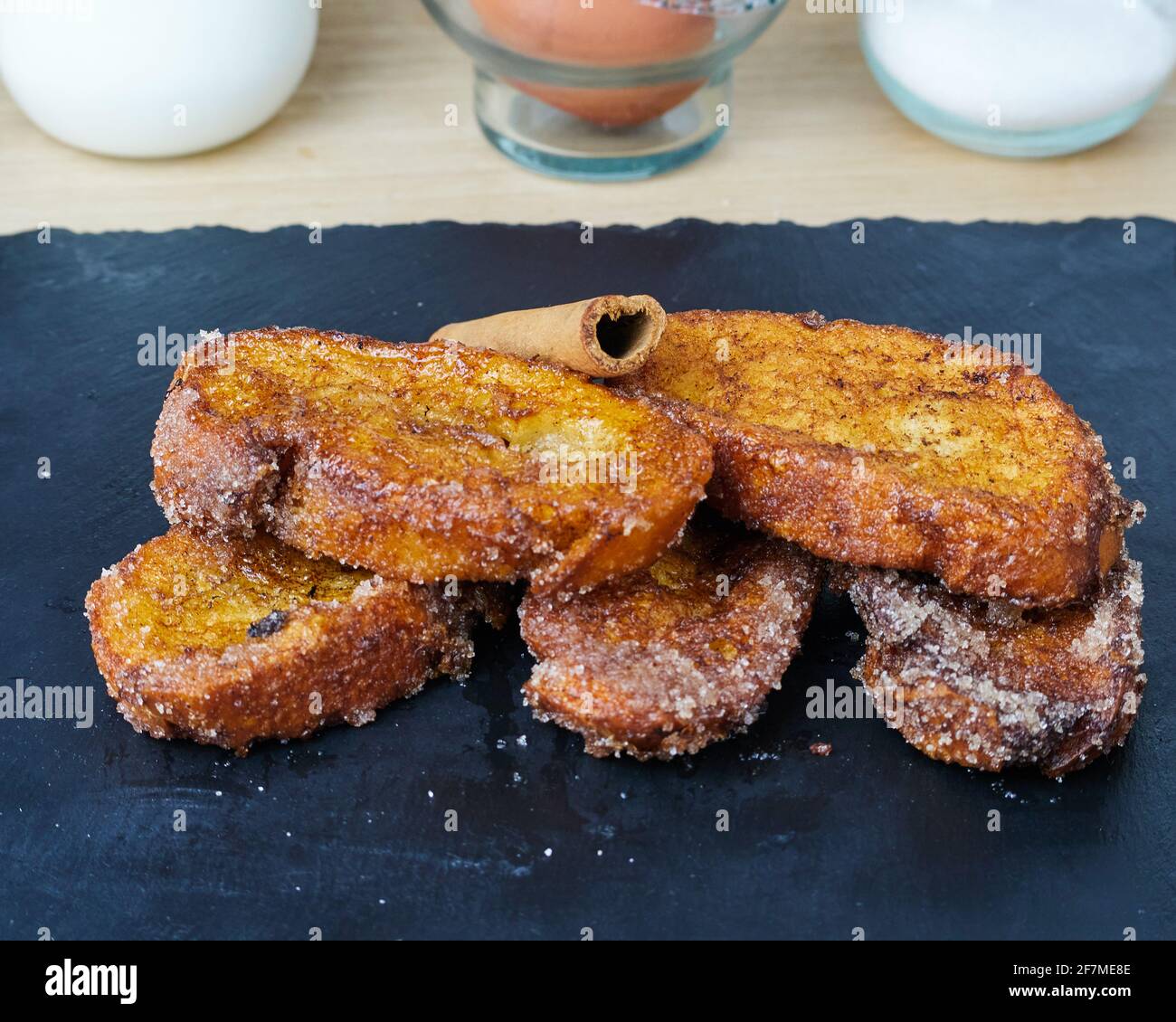 Traditional homemade Spanish Torrijas on a black slate board decorated ...