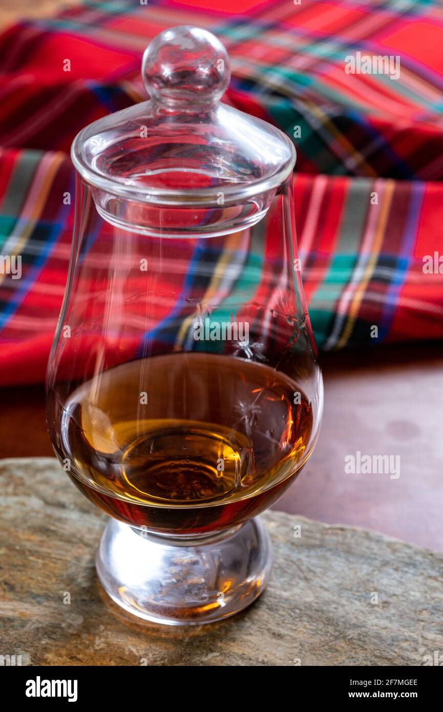 One dram of single malt scotch whisky with red scottish tartan on ...