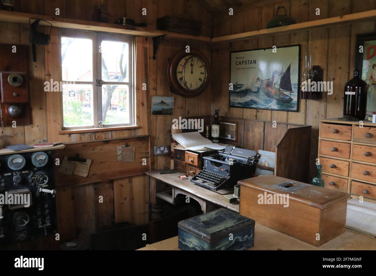 Old inside of railway office with clock on wall, typewriter on wooden ...