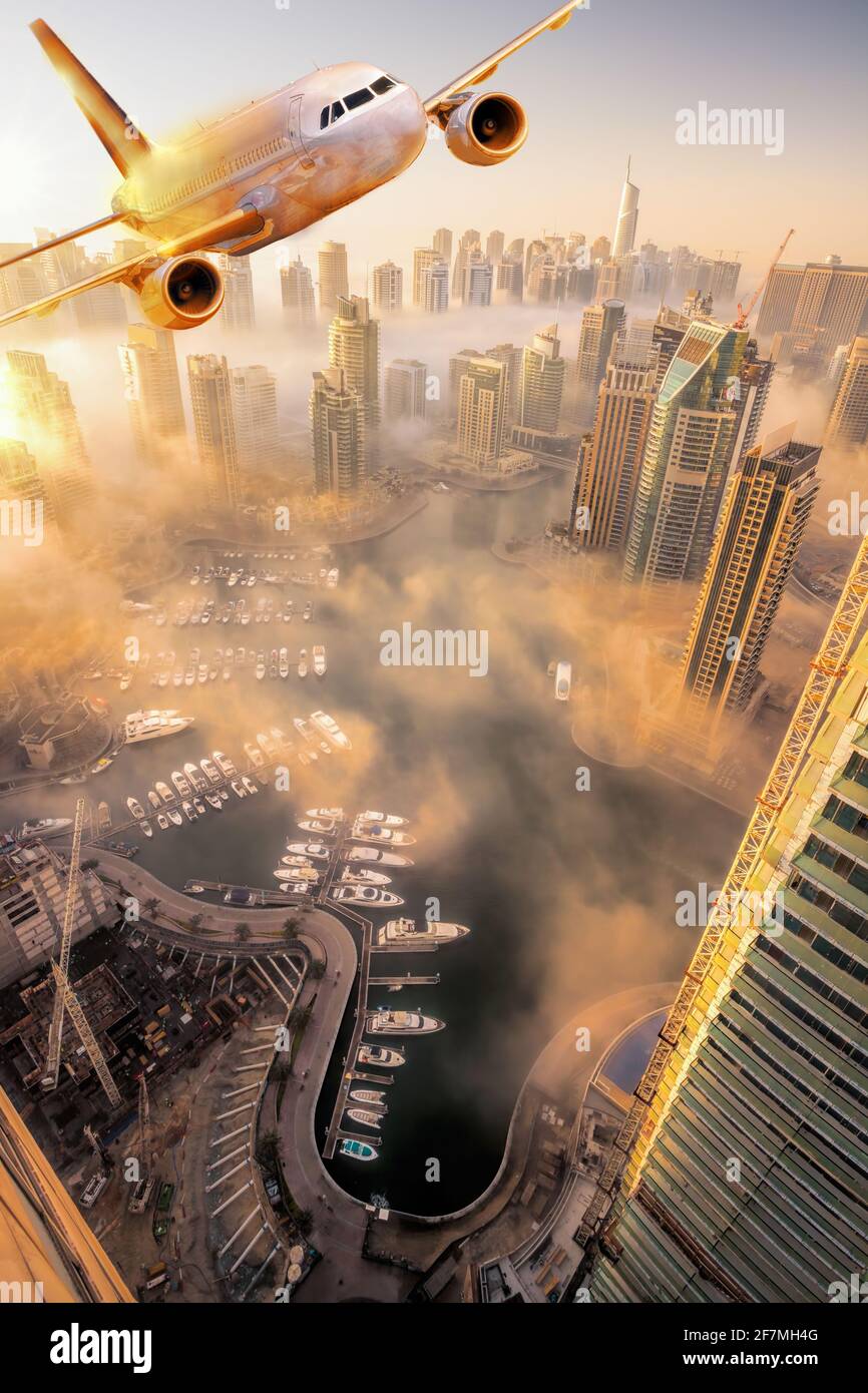 Plane is flying over Dubai Marina against colorful sunset in Dubai city ...