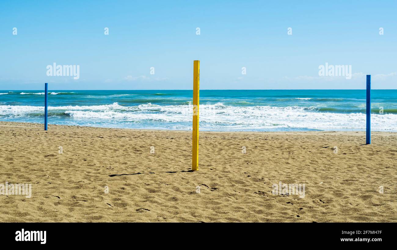 Coloured wooden poles on the deserted beach Stock Photo - Alamy