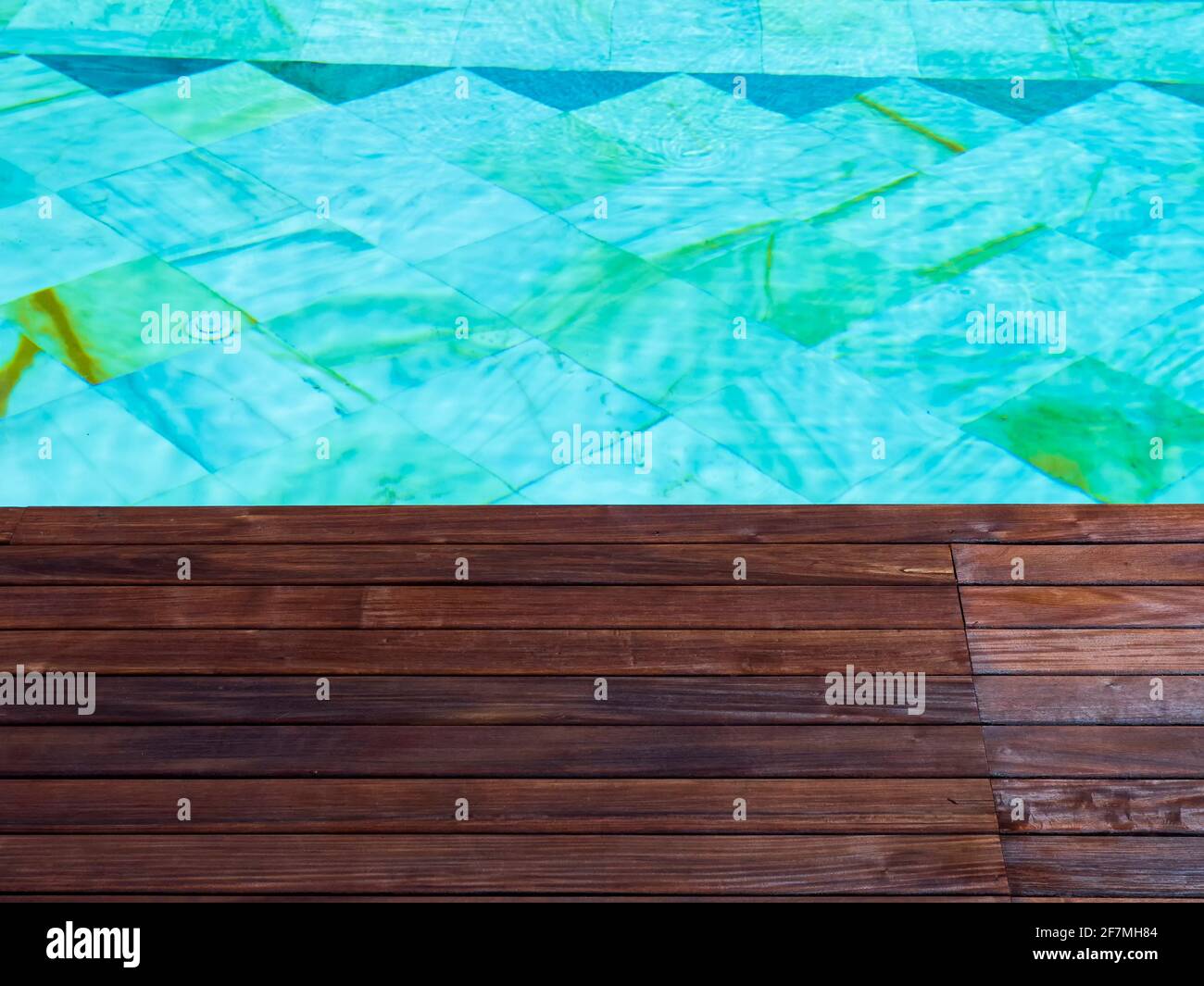 Swimming pool with transparent water and wooden border Stock Photo - Alamy