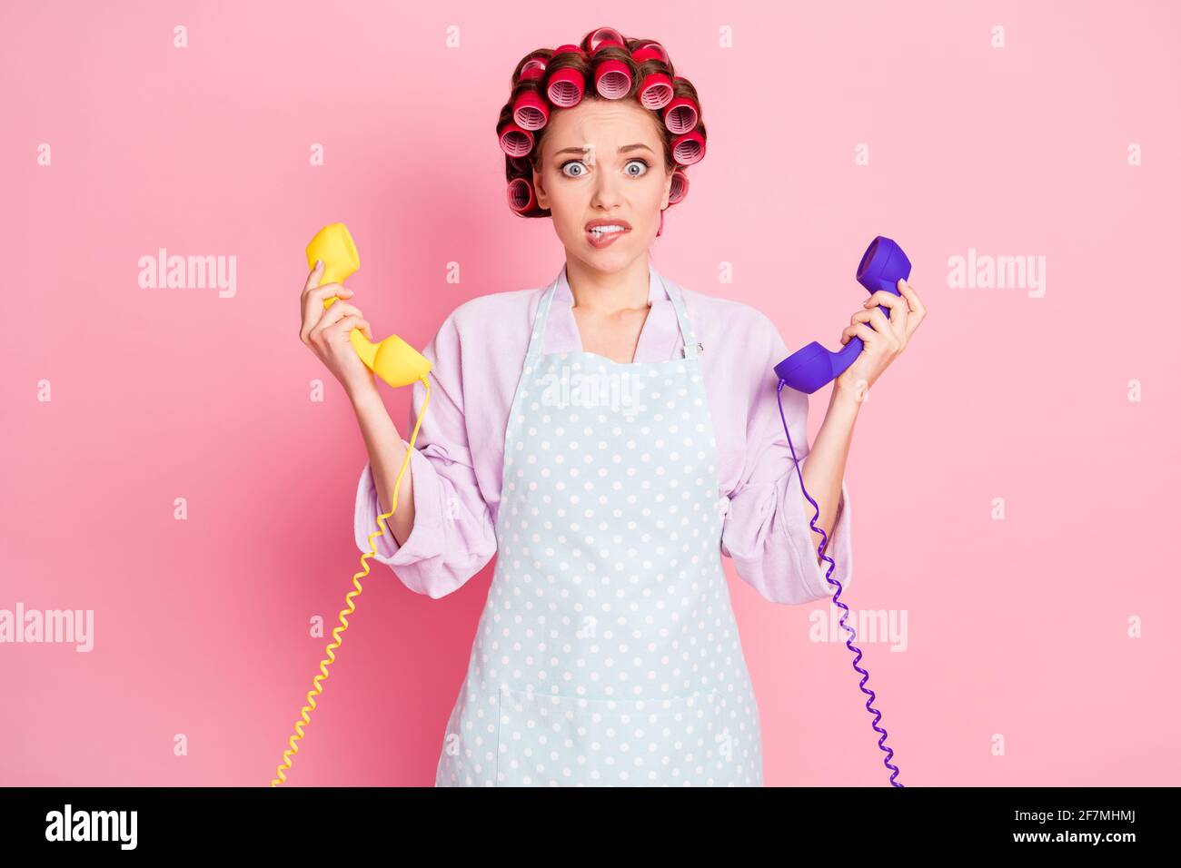Photo of beautiful worried person bite lip hold two old phones isolated ...