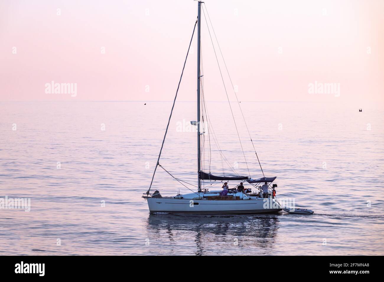 Sailing yacht in the blue sea during beautiful pink sunset. A yacht in ...