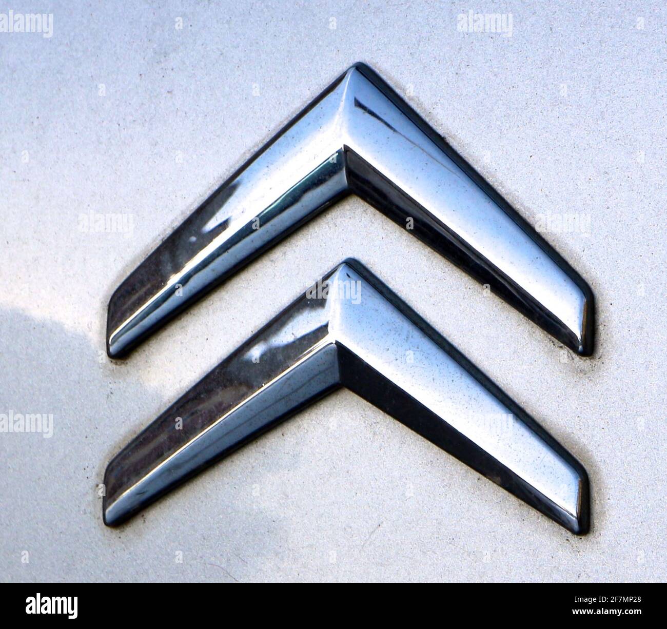 Citroen chrome car badge in natural sunlight with a silver background ...