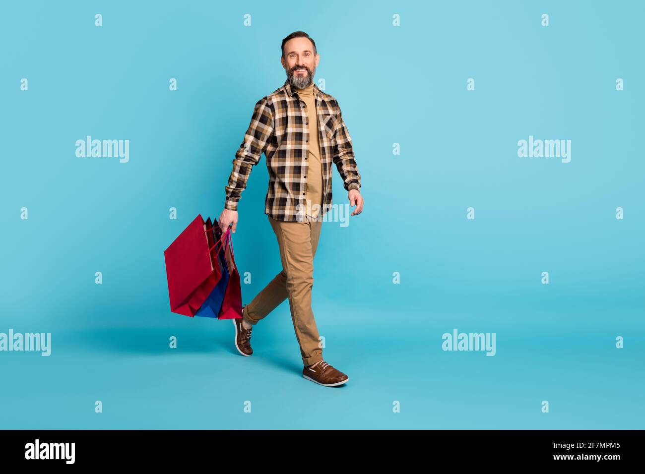 Full size photo of mature positive man go shopping hold bags packages ...