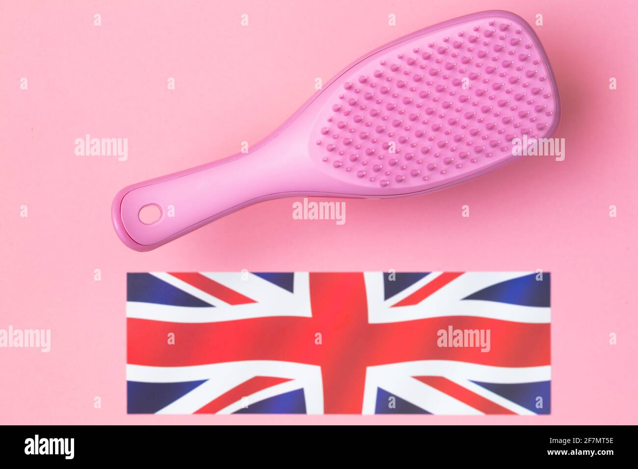 Pink hairbrush and UK flag on pink background Stock Photo - Alamy