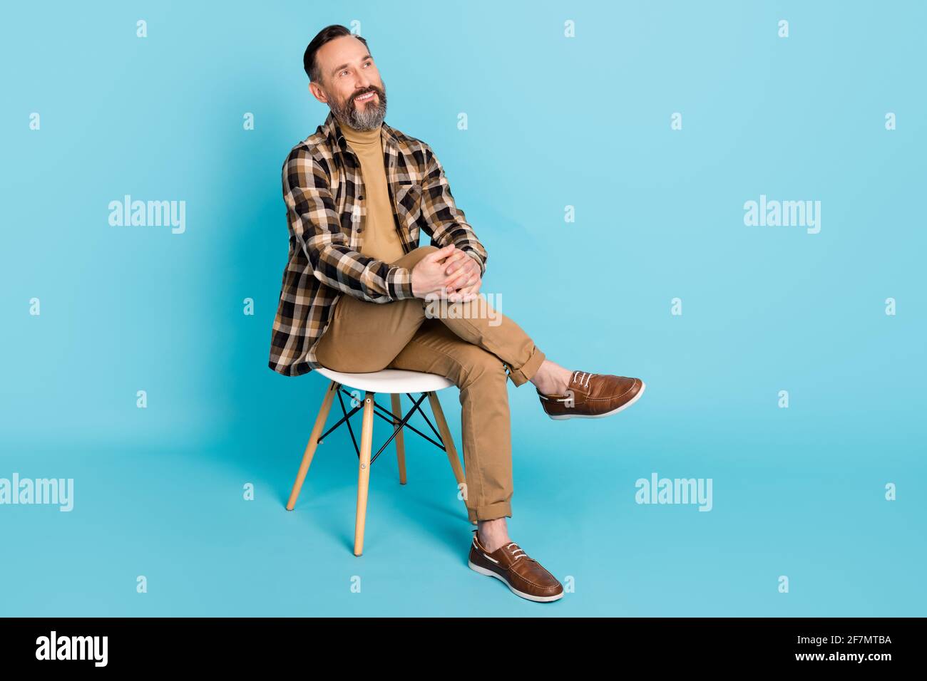 Full length body size photo of man smiling sitting on chair looking ...