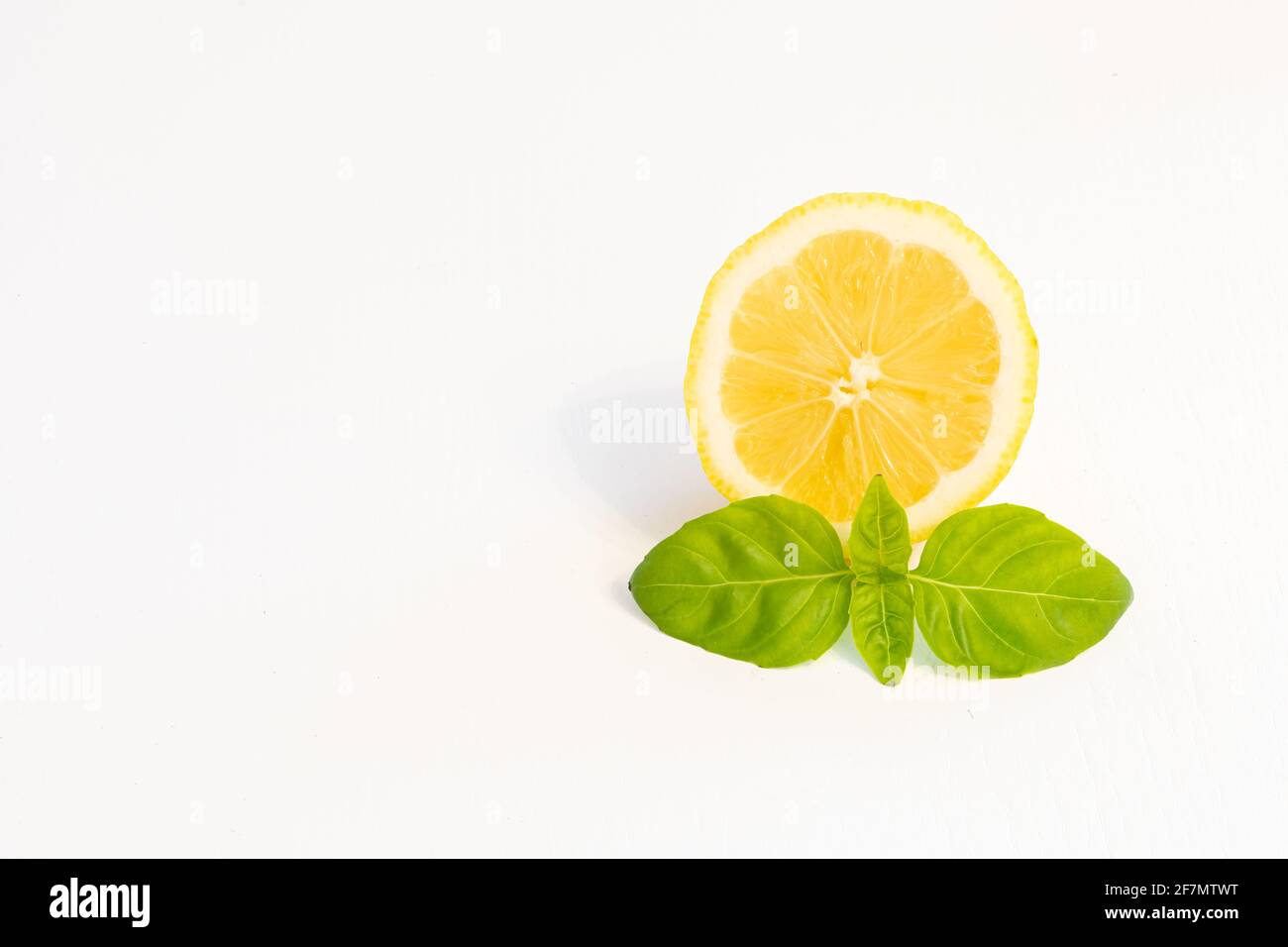 Half yellow lemon fruit isolated on white background with leaf and copy ...