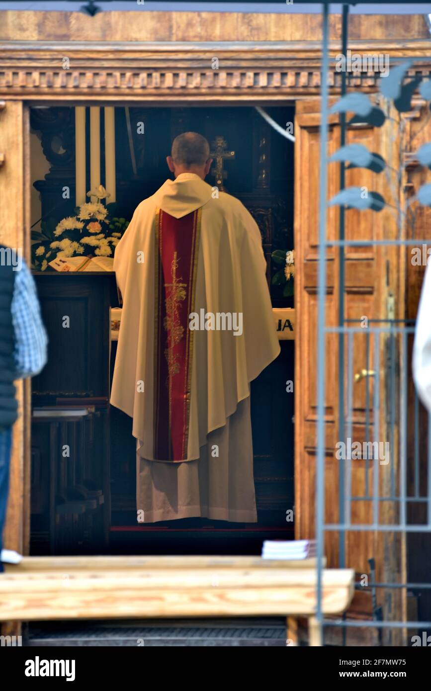 a Catholic priest celebrates Mass in the chapel with the door open ...