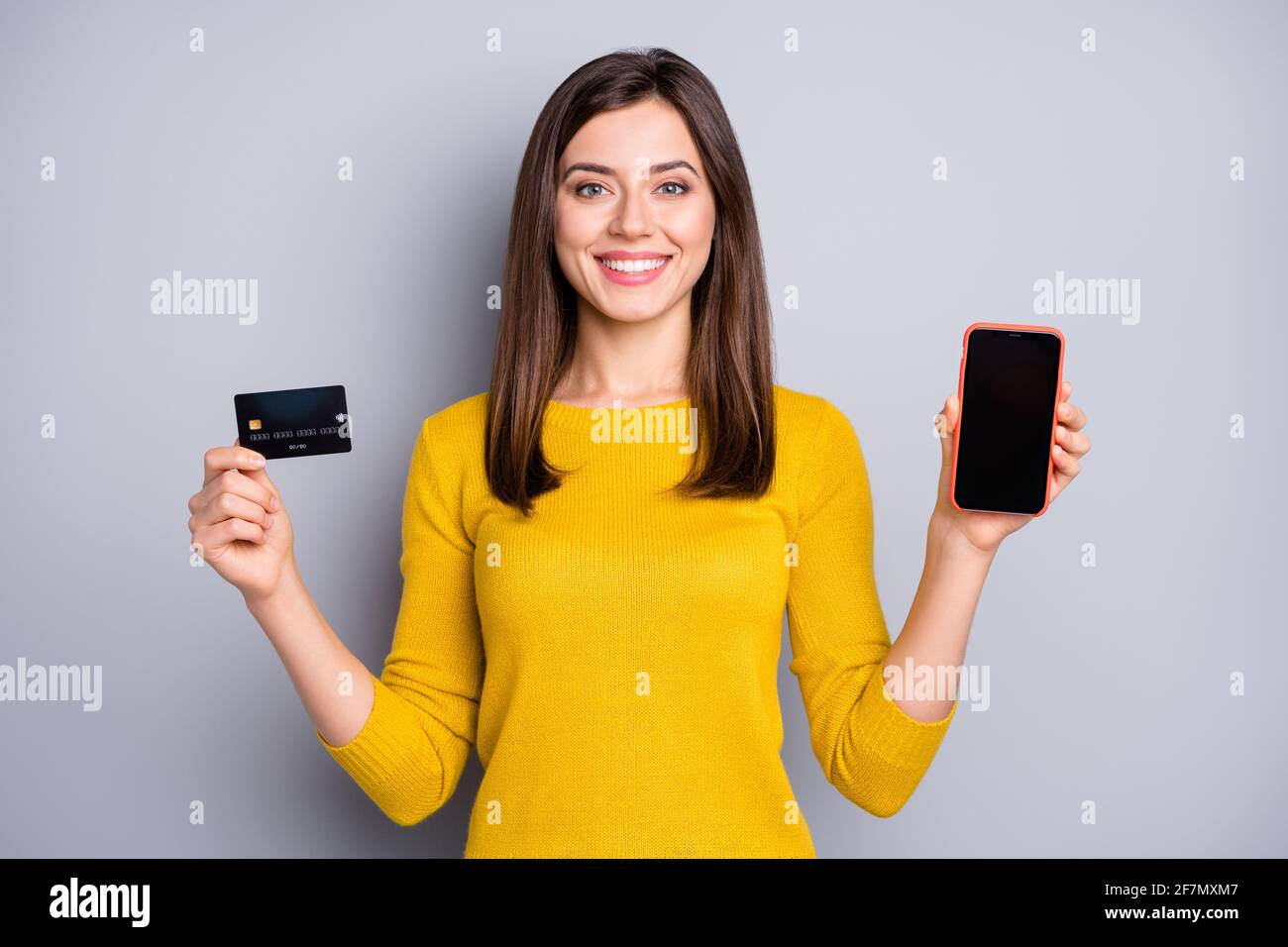 Portrait of pretty content cheerful girl holding in hands gadget bank ...