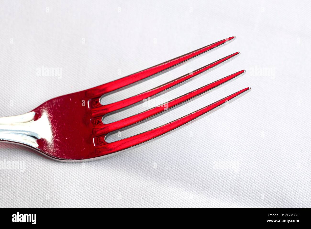 Detail of fork and red light reflected on it Stock Photo - Alamy