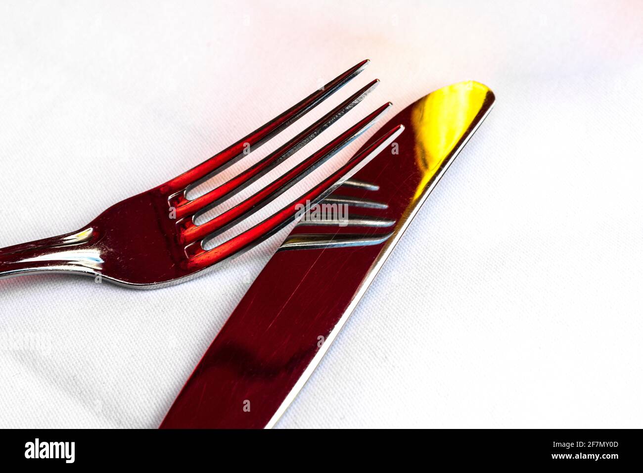 Detail of red fork reflected on knife from an artistic perspective ...