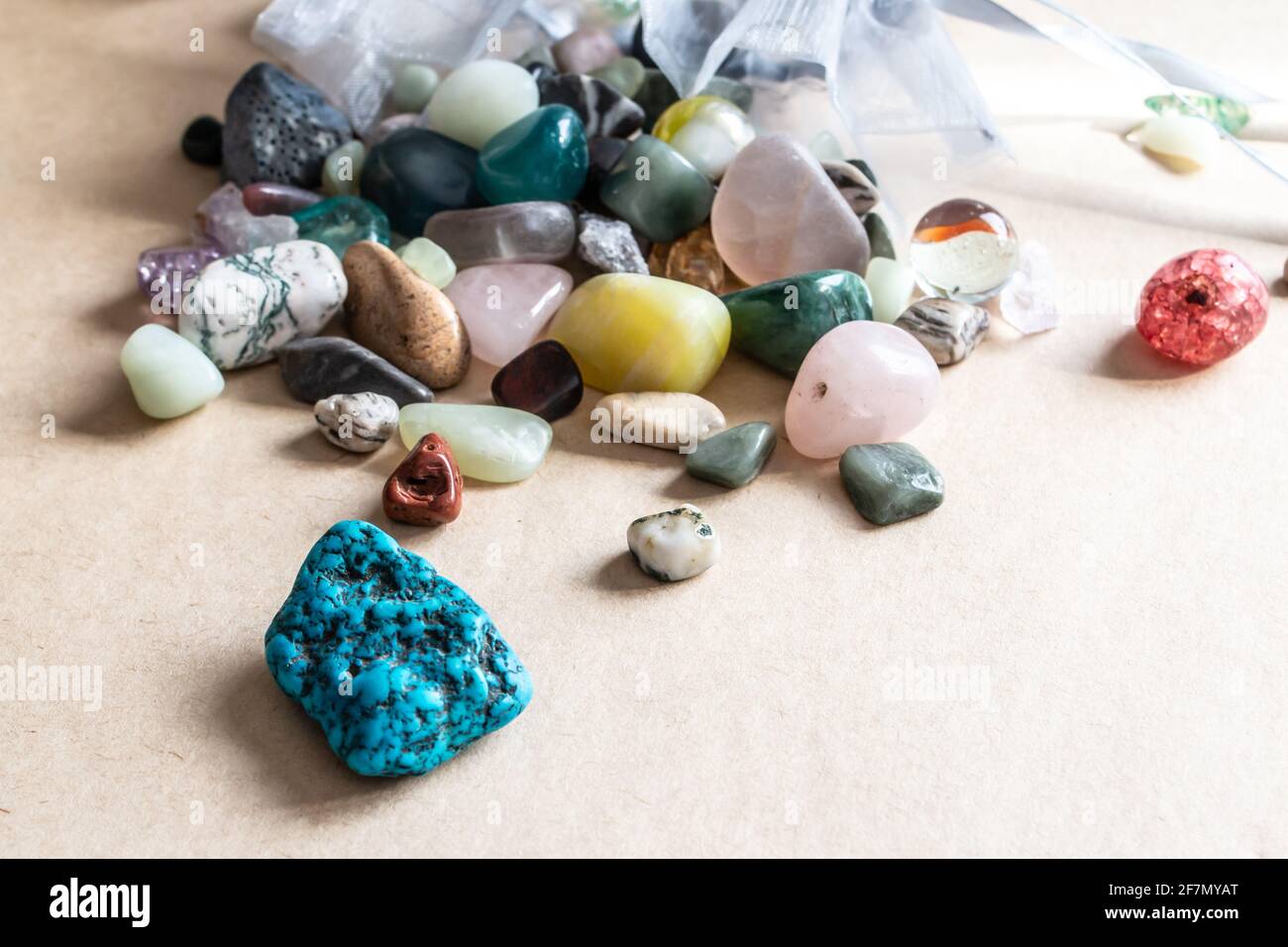 A gem stone collection inside a pale blue silk sachet spilled onto a ...