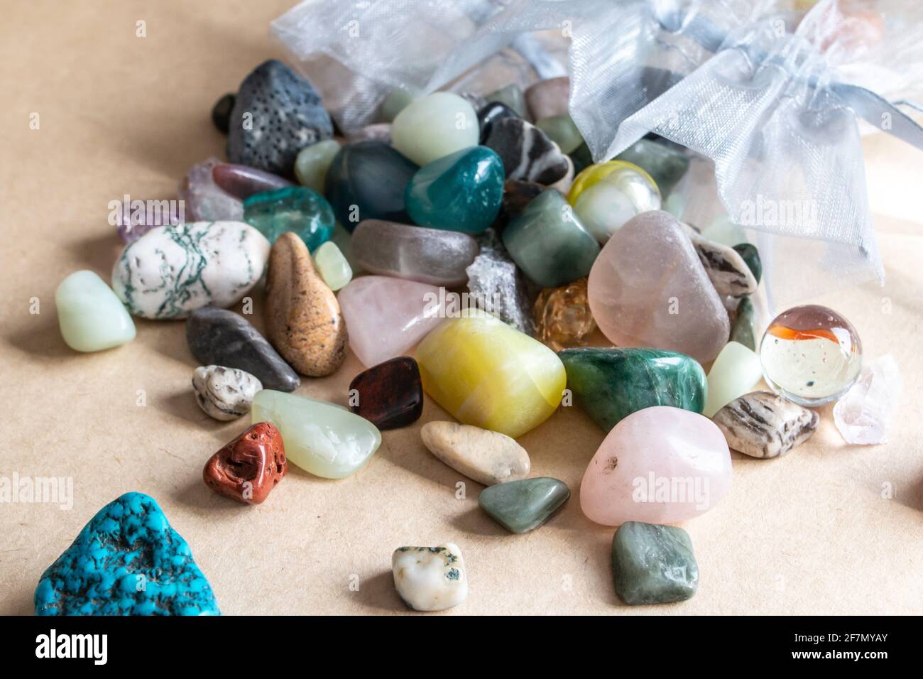 A gem stone collection inside a pale blue silk sachet spilled onto a ...