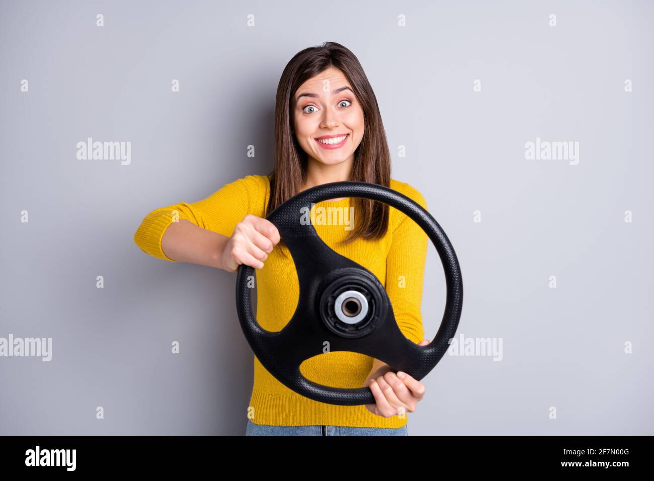 Portrait of pretty funky cheerful girl holding in hands steering wheel ...