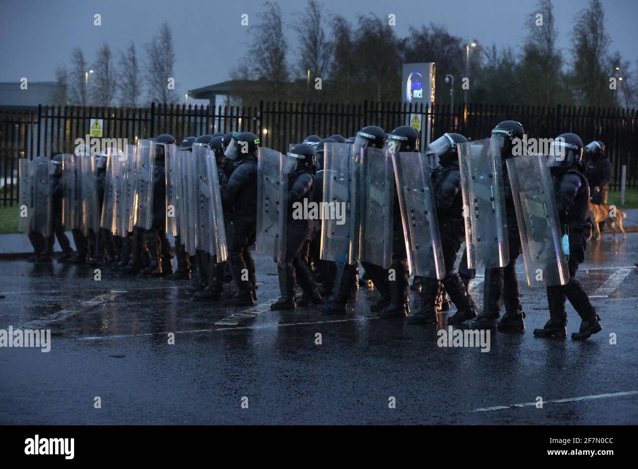 PSNI officers with riot shields line the Springfield road, during ...