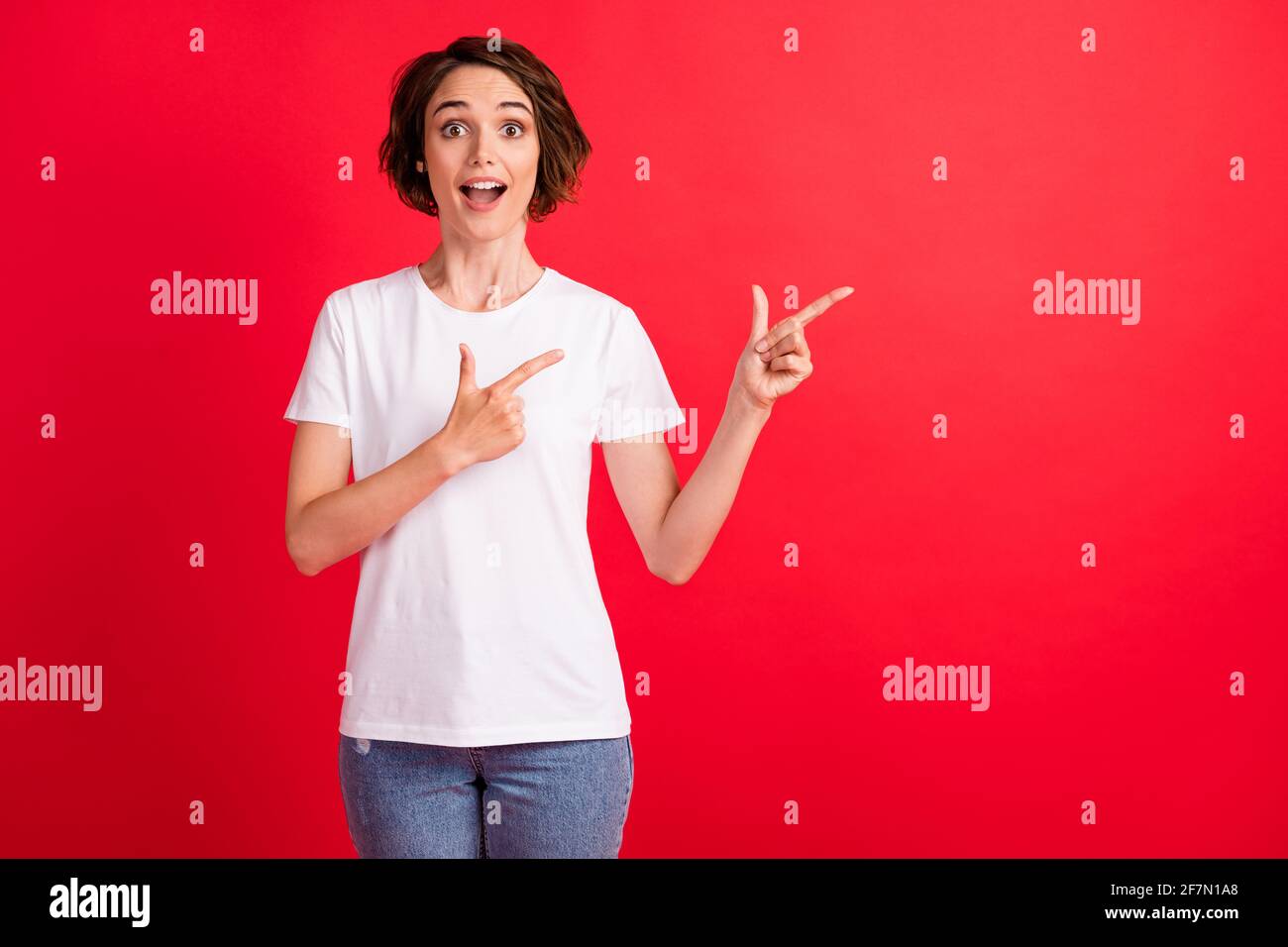 Portrait of attractive amazed cheerful girl demonstrating new offer ad ...