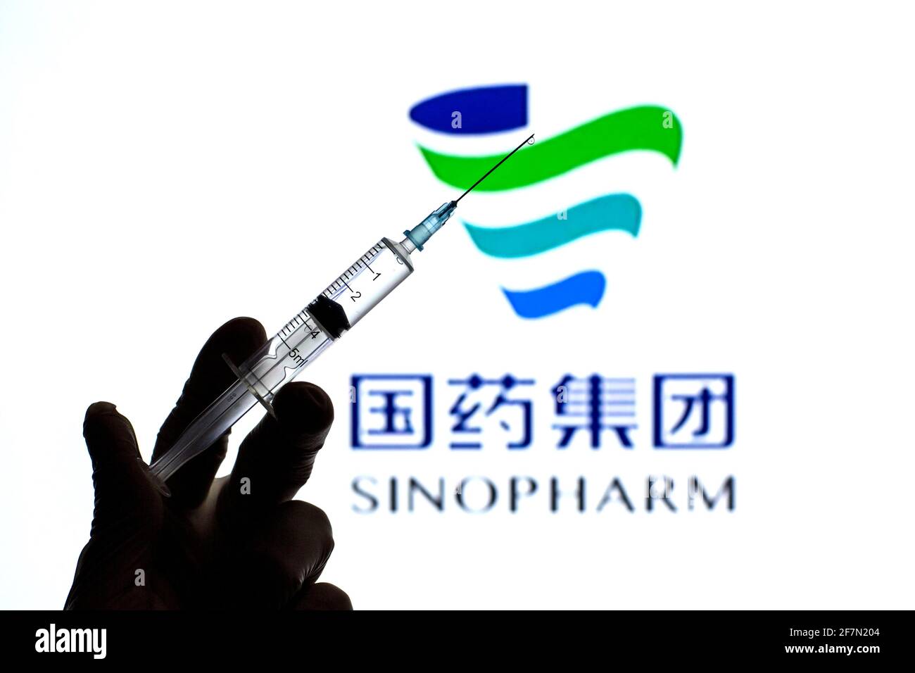 In this photo illustration, a close up of a hand holding a medical syringe seen displayed in ...