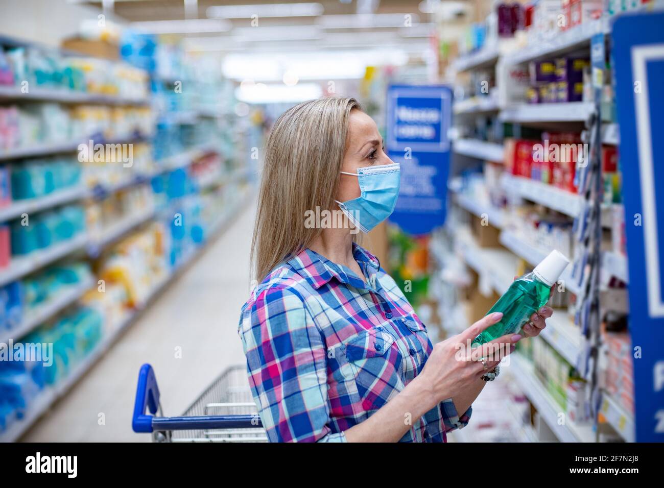 Woman customer buying detergents, cosmetics for laundry in supermarket ...