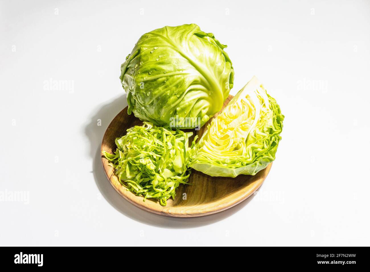 Fresh young shredded cabbage, whole head and cut piece isolated in ...