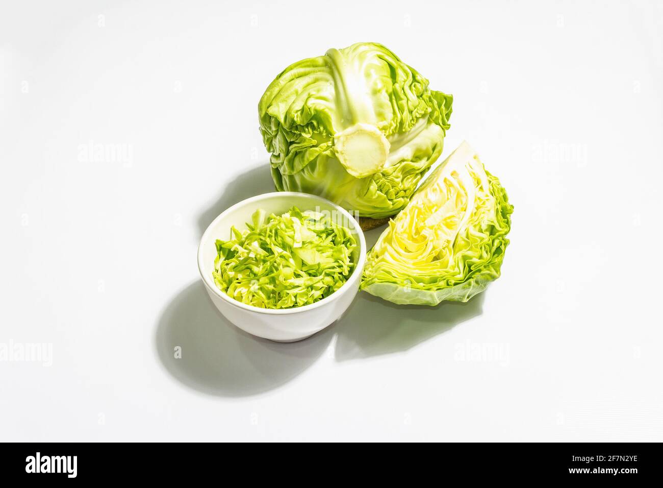 Fresh young shredded cabbage, whole head and cut piece isolated in ...