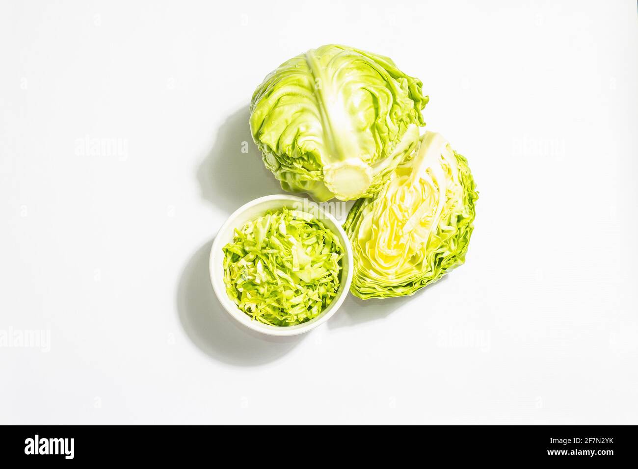 Fresh young shredded cabbage, whole head and cut piece isolated in ...