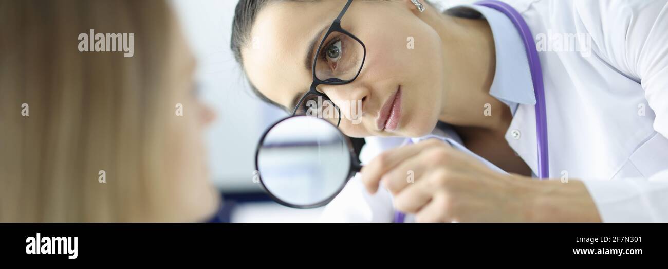 Doctor examines the patient's face through magnifying glass Stock Photo ...