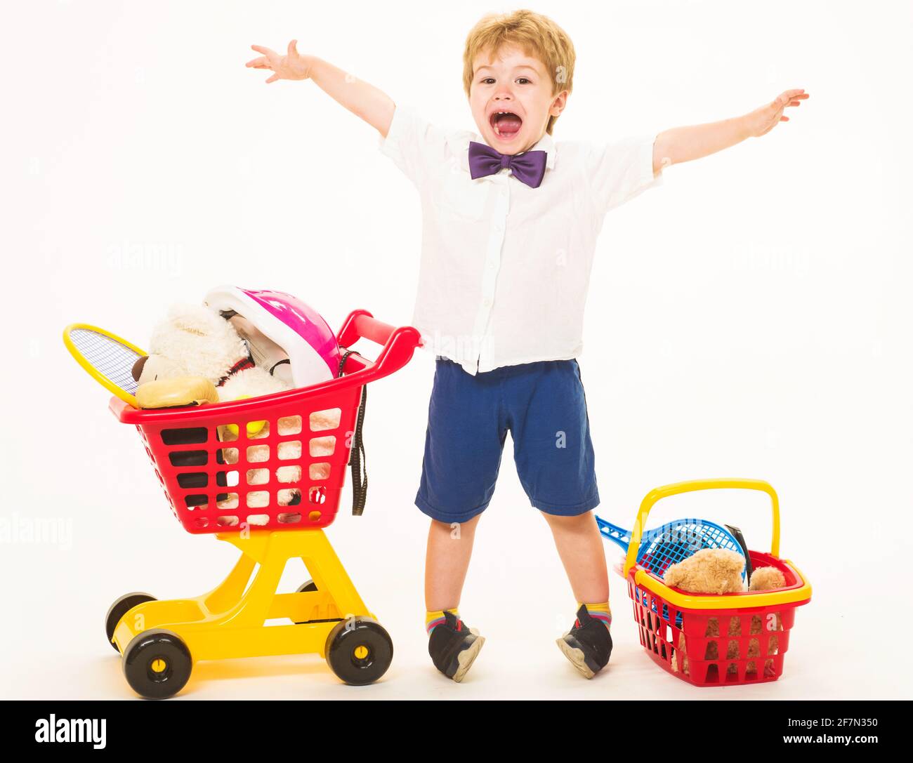 Happy little boy with shopping cart and basket. Child plays in shop ...