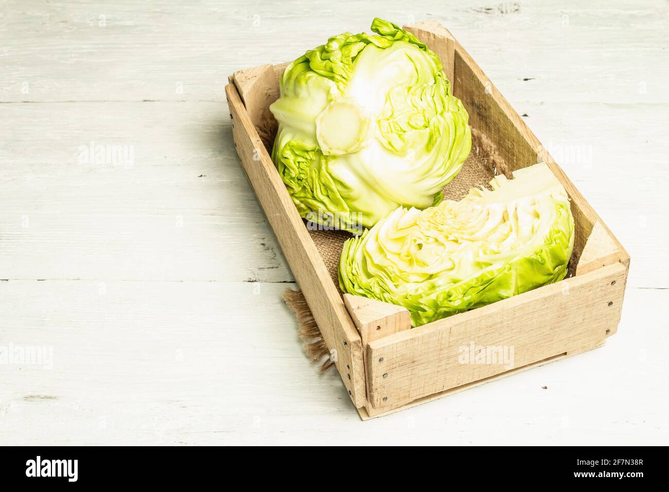 Fresh young cabbage. Wooden crate, old white boards background Stock ...