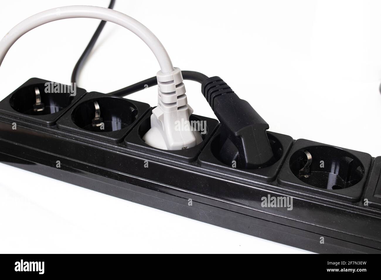 Black extension cord with button and wires on white background close up ...