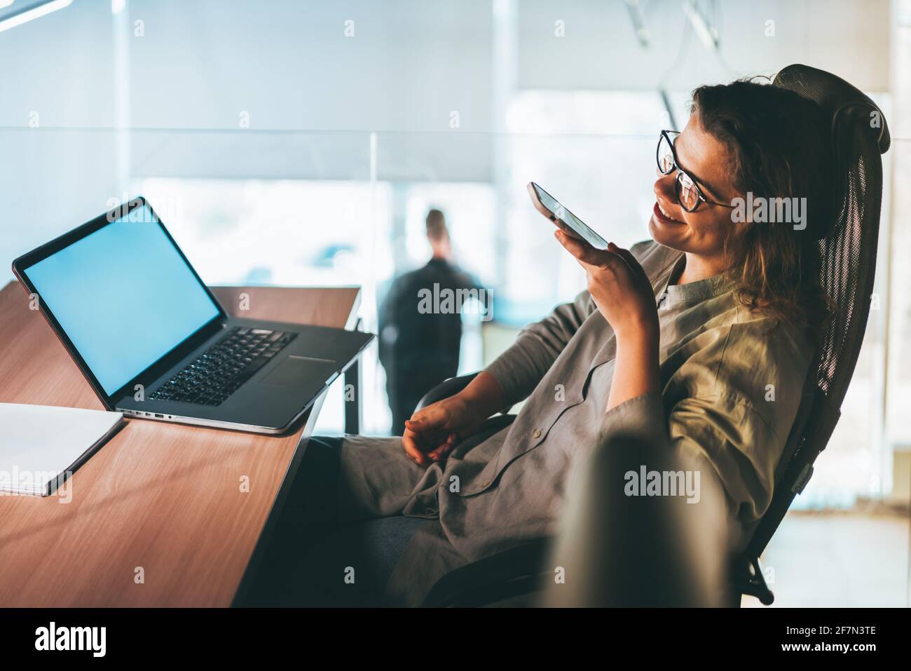 Young business woman recording audio message in the office Stock Photo ...